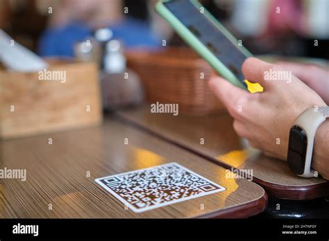 Closeup Of Guest Hand Ordering Meal In Restaurant While Scanning Qr Code With Mobile Phone For