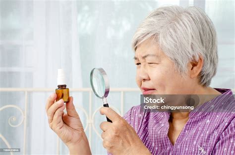나이 의학 건강 관리 및 사람들 개념 가정이나 병원 사무실에서 돋보기로 자신의 손에 약을보고 의심 노인 여성 돋보기 광학 기기에 대한 스톡 사진 및 기타 이미지 Istock