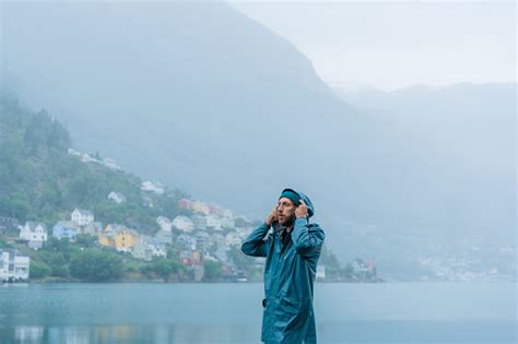 비가 오는 동안 피요르드의 배경에 서 있는 파란 비옷을 입은 남자 가을에 대한 스톡 사진 및 기타 이미지 가을 건강한 생활방식 건축 Istock