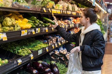 바이러스 성 전염병 발병 시 안전한 쇼핑 관행 상점에서 장갑을 낀 채소를 쇼핑하는 젊은 여성 슈퍼마켓에 대한 스톡 사진 및 기타 이미지 Istock