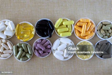 중앙에 의약품이 있는 베이지색 배경 둥근 모자에 다양한 알약과 의약품 평면도 생선 기름 비타민 D 활성탄 커큐민 Coq10 효소