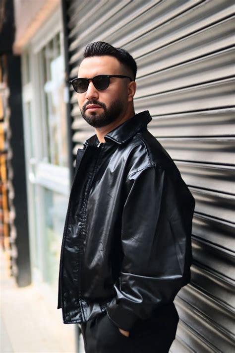 Стильный мужчина в черной кожаной куртке на улице · Бесплатные стоковые фото