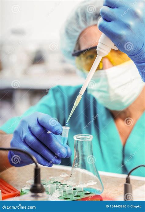 Scientist With Test Tubes And Flasks Conducting An Experiment In A Science Lab Stock Photo