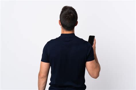 Premium Photo Young Caucasian Man Using Mobile Phone Isolated In Back