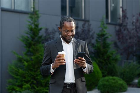 커피 브레이크 사무실 근처에 있는 젊은 아프리카계 미국인 사업가 그는 커피와 전화를 들고 있습니다 커피 마실 것에 대한 스톡 사진 및 기타 이미지 Istock