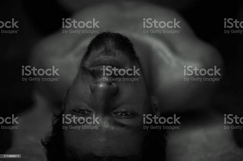 피트 하는 남자의 본격적인 수평 클로즈업 샷 어두운 친밀한 분위기에서 요가를 연습 강한 남성 아사나바닥에 누워 필름 그레인 효과 운동몸에 잘 생긴 운동체가 실내에서