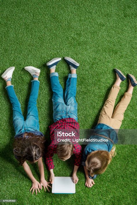 잔디에 누워 있는 동안 디지털 태블릿을 사용 하 여 어린이의 오버 헤드 보기 아이에 대한 스톡 사진 및 기타 이미지 아이 태블릿 3 명 Istock