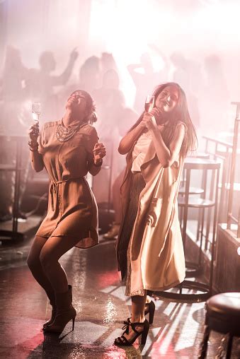 클럽에서 춤추는 샴페인 안경을 쓴 두 명의 미소 짓는 여성 나이트클럽에 대한 스톡 사진 및 기타 이미지 나이트클럽 단체 댄스 플로어 Istock