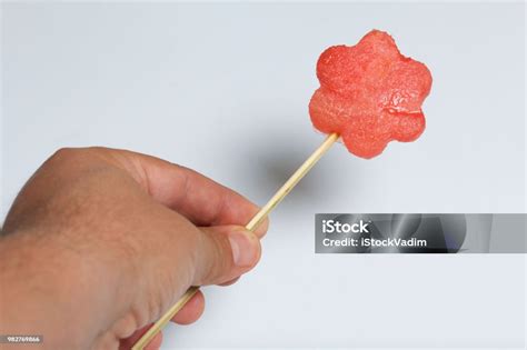 수 박의 펄프의 조각 우표와 함께 잘립니다 그들은 다양 한 형태의 주어 집니다 피크닉 꼬치에 현악기 남자는 그의 손에 한 꼬치를 들고 있다 0명에 대한 스톡 사진 및 기타