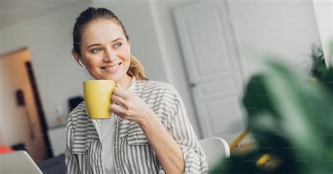 프리랜서 활동 행복한 미소를 짓는 여인의 초상화를 허리 위로 올려 노트북을 들고 테이블에 앉아 커피를 마시고 있다 주변 홈