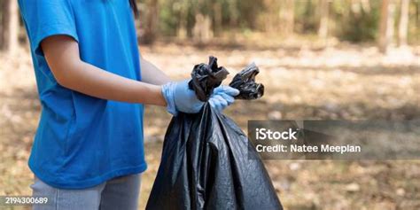 숲에서 쓰레기 봉투를 들고 환경 정화와 지역 사회 봉사에 대한 헌신을 보여주는 자원 봉사자 공동체에 대한 스톡 사진 및 기타 이미지 공동체 긍정적인 감정 표현 깨끗한