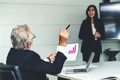 수석 임원 관리자 회의실에서 젊은 사업가의 재정 프레젠테이션을 듣고 비서는 상사에 게 보고서를 제공 합니다 비즈니스 작업 공간