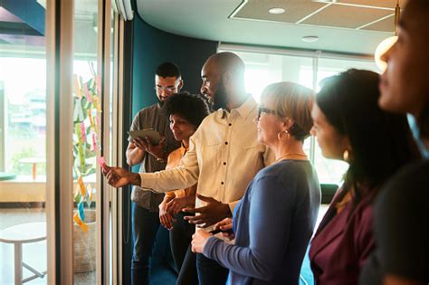 사무실에서 접착 노트로 브레인스토밍하는 다양한 사업가들의 웃는 그룹 렌즈 플레어에 대한 스톡 사진 및 기타 이미지 렌즈 플레어 비즈니스 일터 Istock