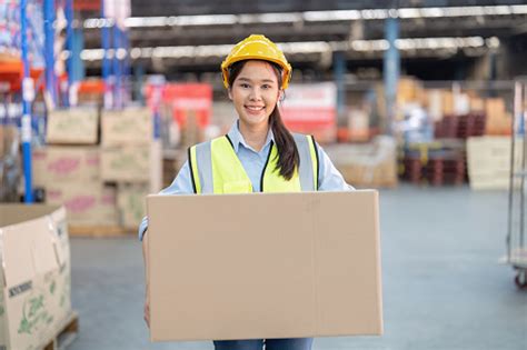 대형 창고 보관 창고에서 일하는 직원이 웃는 초상화를 들고 무거운 판지 상자를 들어 올립니다 25 29세에 대한 스톡 사진 및 기타 이미지 Istock