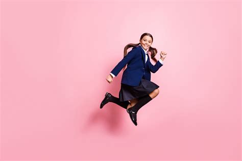 전체 길이의 몸 크기 보기 그녀의 좋은 매력적인 꽤 기쁘다 쾌활한 작은 소녀 점프 실행 러쉬 첫 번째 레슨 을 통해 분리 핑크 파스텔 색상 배경 갈색 머리에 대한 스톡 사진