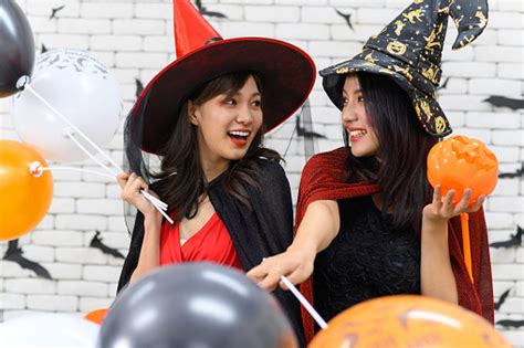 할로윈장식 배경에 호박 잭 O 랜턴과 풍선을 들고 마녀 의상을 입고 아름다운 젊은 아시아 여성의 초상화 2명에 대한 스톡 사진 및 기타 이미지 Istock