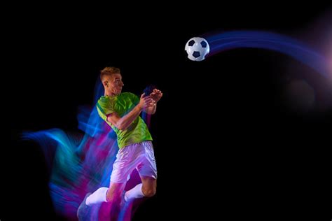 골 젊은 축구 네온 빛에 어두운 배경에 고립 된 공과 함께 움직임과 행동에있는 축구 선수 성취 창의력 스포츠 에너지 챔피언십의 개념 스포츠팀에 대한 스톡 사진 및 기타