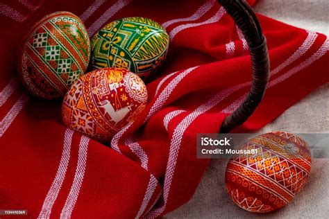 동부 유럽 특유의 복잡 하 고 복잡 한 패턴을 가진 소박한 빈티지 등나무 바구니와 빨간 천으로 3 개의 염색 계란과 봄 휴가와 행복 한 부활절 개념 0명에 대한 스톡 사진