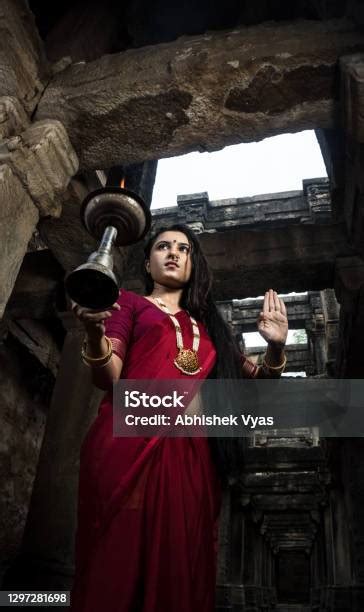 전통적인 인도 빨간 사리 금 보석과 화재 판을 들고 팔찌를 입고 오래된 스텝 웰에 인도 소녀 18 19세에 대한 스톡 사진 및 기타 이미지 Istock