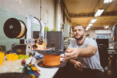 젊은 남성 3d 프린터를 사용하는 한 공사장 워크숍입니다 3d 프린팅 필라멘트에 대한 스톡 사진 및 기타 이미지 3d 프린팅