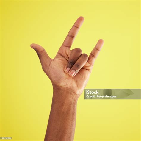 노란색 배경에 뿔 사인을 만드는 인식 할 수없는 남자의 스튜디오 샷 뿔 모양에 대한 스톡 사진 및 기타 이미지 뿔 모양