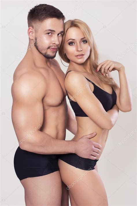 Sexy Fit Muscled Couple In Sportswear On Neutral Grey Background Stock