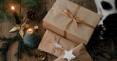 세련된 크리스마스 선물은 공예 종이 귀여운 고양이 양초 가위 소박한 나무에 전나무 가지에 싸여 있습니다 현대적인 간단한