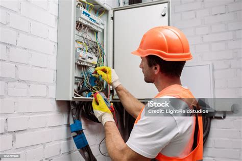 배전 상자 근처에서 멀티미터를 들고 있는 하드햇과 장갑을 낀 잘생긴 전기 기술자 검사 보기에 대한 스톡 사진 및 기타 이미지 검사 보기 멀티미터 모자류 Istock