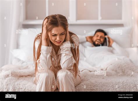 Young Woman Cannot Sleep Because Of Her Husband Using Tablet Computer