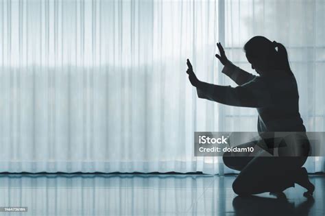 일몰 시간에 현대 교회에서 무릎을 꿇고 기도하는 여자의 실루엣 하느님께 드리는 여성 가톨릭 기도 예배는 믿음으로 새벽에 가정에서