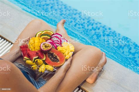편안 하 고 호텔 수영장에서 과일 접시를 먹는 젊은 여자 이국적인 여름 다이어트입니다 다리 위에서 상위 뷰 수영장으로 건강 식품의 사진 열 대 해변 라이프 스타일 개념에