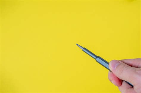 남자의 손은 밝은 노란색 배경에 몸통 노즐이있는 작은 드라이버를 보유하고 있습니다 복사 공간 텍스트 공간 공구상자에 대한 스톡 사진 및 기타 이미지 Istock