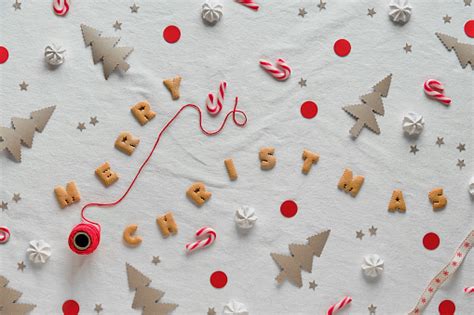 쿠키로 만든 메리 크리스마스 텍스트 갈색과 빨간색 종이와 달콤한 마시멜로로 자른 Xmas 장식 실루엣 친환경 적인 Xmas 장식