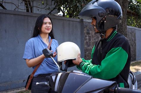 Premium Photo Happy Commercial Motorcycle Taxi Driver Giving Helmet