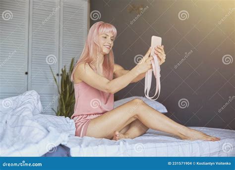 Seductive Woman With Pink Hair In Elegant Silk Pajamas Takes Selfie On