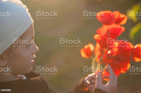 이른 봄에는 따뜻한 일몰 빛에 의해 그녀의 손에 백라이트에서 오렌지 꽃의 부케와 흰 따뜻한 모자에 잘생긴 작은 소녀 검은색에 대한 스톡 사진 및 기타 이미지 Istock