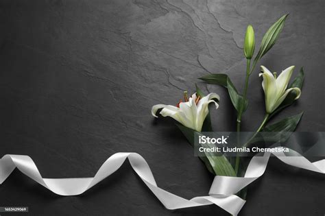 검은 테이블 위에 하얀 백합과 리본이 놓여 있고 텍스트를 위한 공간이 평평하게 놓여 있다 장례식 상징 장례식장에 대한 스톡 사진 및 기타 이미지 Istock