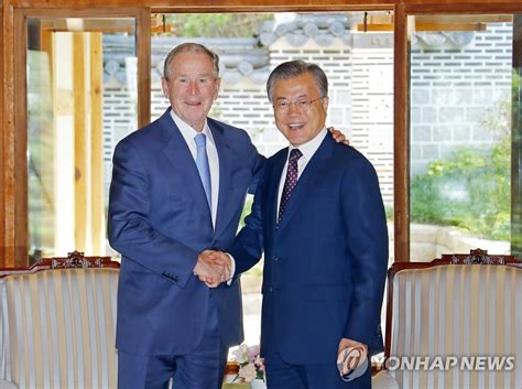 文在寅与小布什握手 韩联社