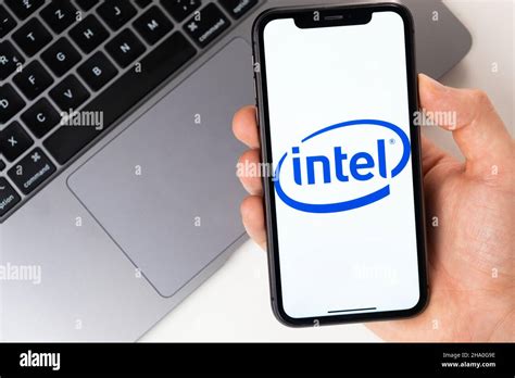 Intel Mobile Application On The Smartphone Screen A Mobile Phone In A Man Hand Near An Open