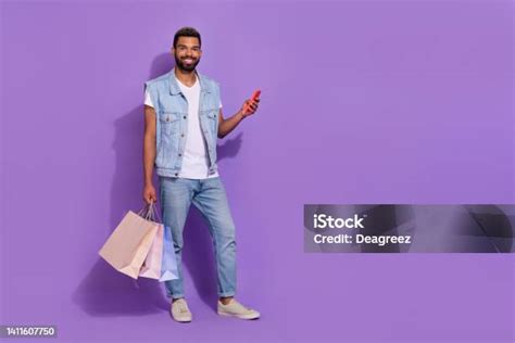 꽤 재미있는 남자의 전체 길이 사진 청바지 허리 코트를 입고 쇼핑객 현대 장치 빈 공간 고립 된 보라색 배경 18 19세에 대한 스톡 사진 및 기타 이미지 Istock