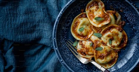 라비올리와 포크를 얹은 파란색 접시 사진 Unsplash의 음식 사진 이미지