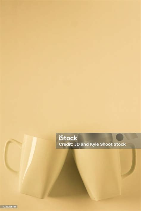 노란 배경에 있는 단색 노란 커피 머그잔 2개 텍스트 복사 또는 복사 공간을 위한 빈 빈 공간으로 환호성을 지켜고 있습니다 견고한 배경을 가진 두 컵의 현대적인 최고 뷰