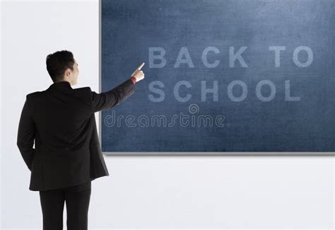 Rear View Of Asian Teacher Man Pointing Chalkboard With Back To Babe Text Stock Photo Image