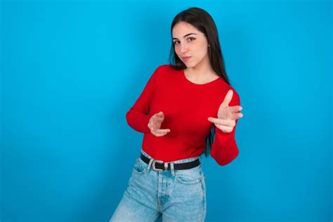 Premium Photo Joyful Woman Wink And Points Index Fingers At Camera