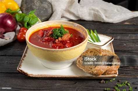 소고기와 사워 크림을 곁들인 보르슈트 사탕무 감자 시리얼 삶은 고기로 만든 전통 우크라이나 야채 수프와 나무 주방 테이블에 세라믹 그릇에 호밀 빵 두 조각 0명에 대한 스톡