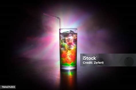 어두운 톤의 연기가 자욱한 배경이나 유리에 화려한 칵테일에 튀는 칵테일 유리 파티 클럽 엔터테인먼트 혼합 된 빛 0명에 대한 스톡 사진 및 기타 이미지 Istock