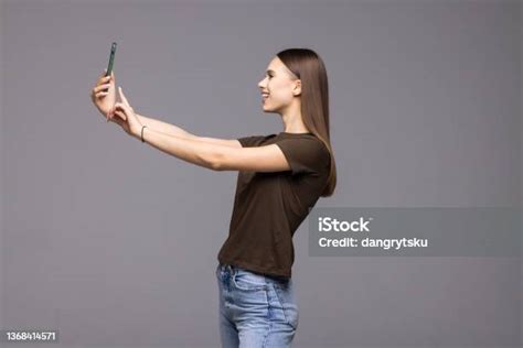 흰색 배경에 고립 된 스마트 폰에서 셀카 사진을 만드는 웃는 여성의 초상화 Brand Name Smart Phone에 대한 스톡 사진 및 기타 이미지 Brand Name