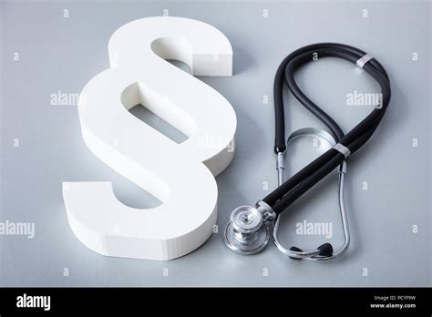 Close Up Of Stethoscope And Paragraph Symbol On Grey Background Stock