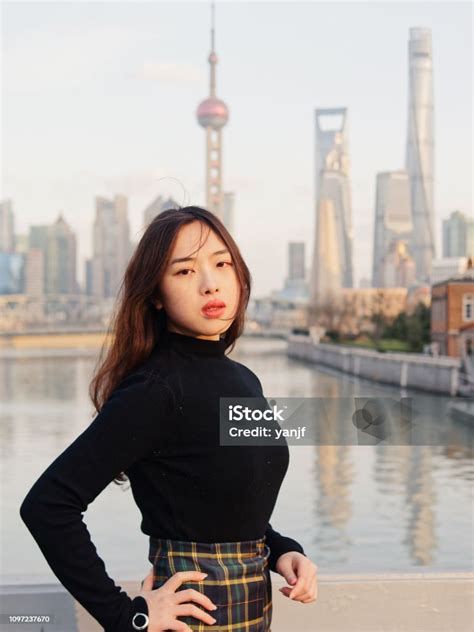 검은 옷과 함께 포즈에 아름 다운 젊은 갈색 머리 여자가을 황혼 빛에 상하이 외 탄 랜드마크 건물 배경 흐림 감정 사람 미용