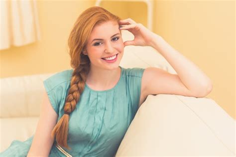 Premium Photo Happy Redhead Sitting On The Couch Looking At Camera
